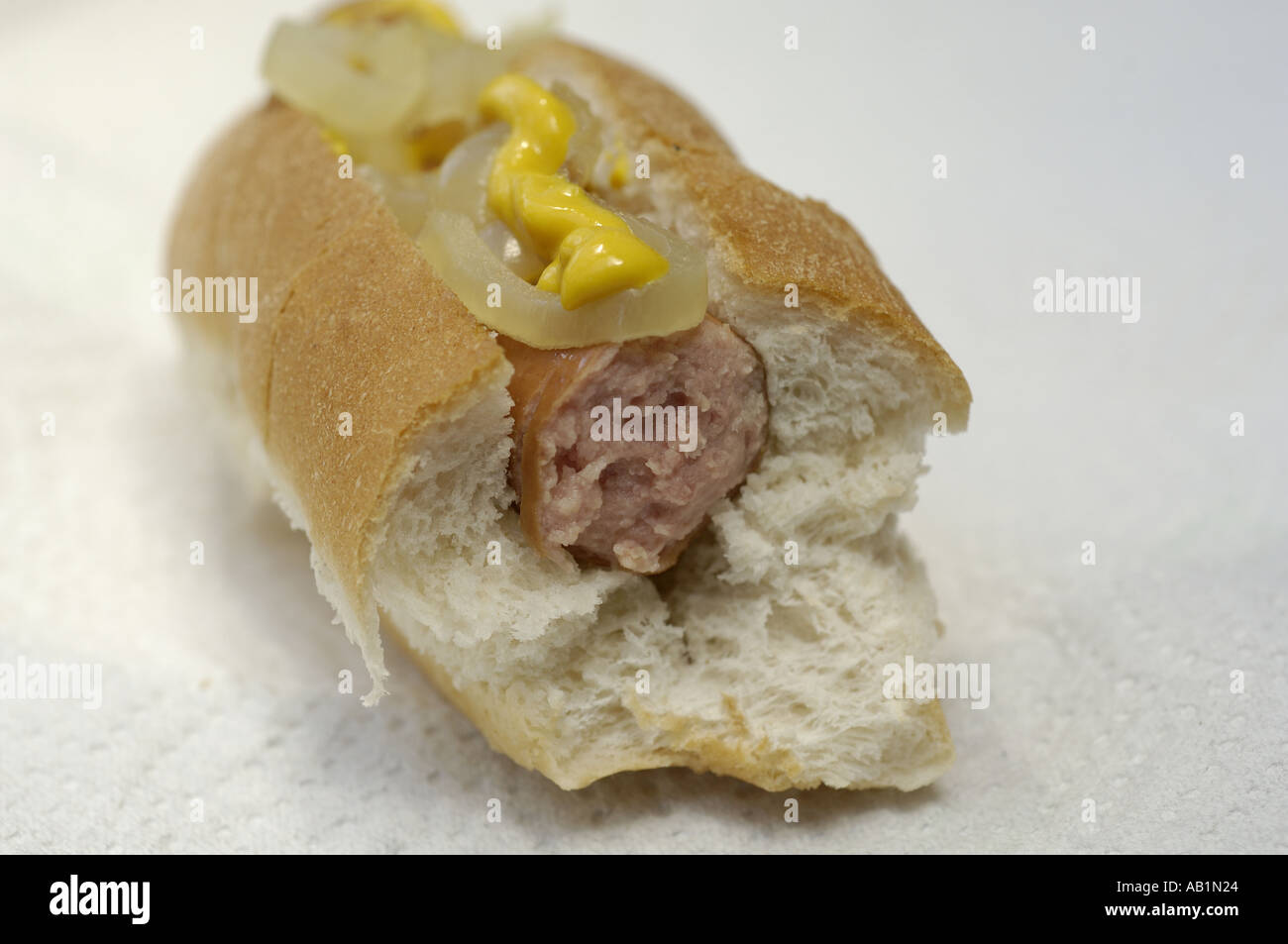 British Hot Dog with onions mustard half eaten Stock Photo - Alamy