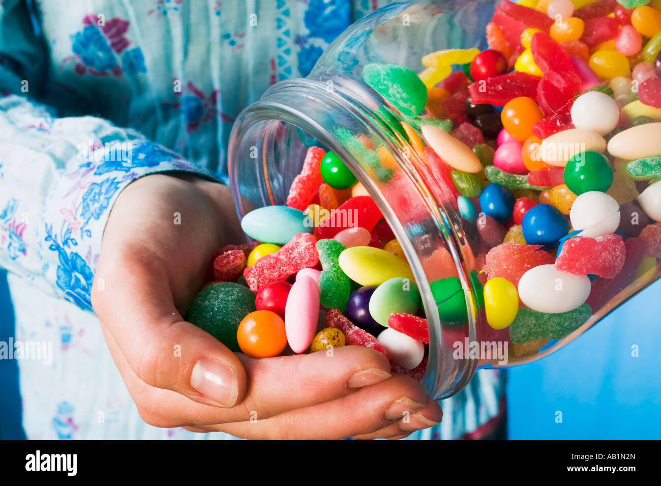 Person tipping sweets out of jar FoodCollection Stock Photo - Alamy