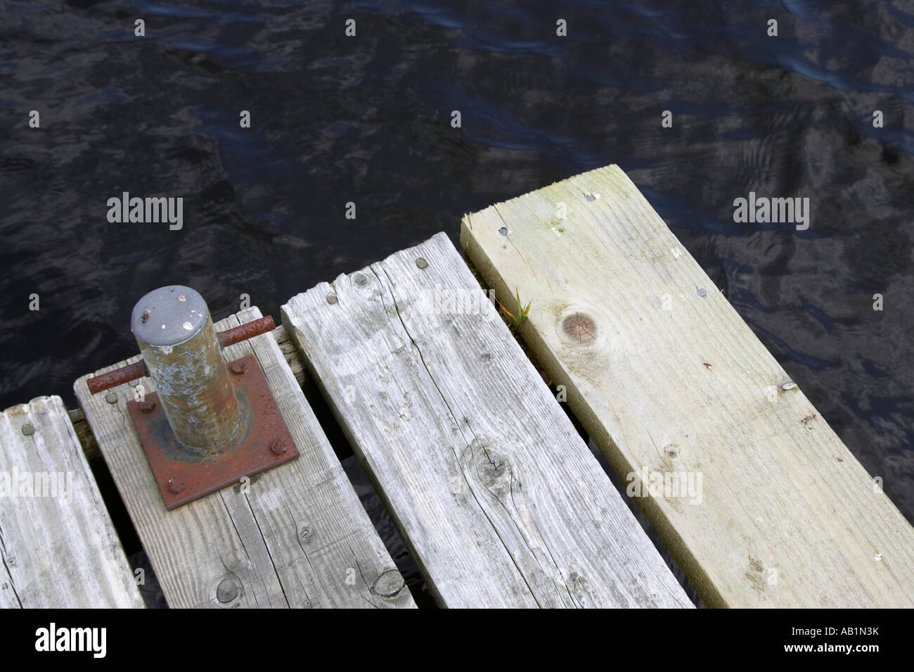 old metal boat mooring post attached to wooden planks with one repaired ...