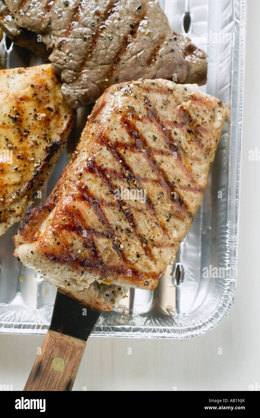 Grilled meat in aluminium grill tray overhead view FoodCollection Stock ...