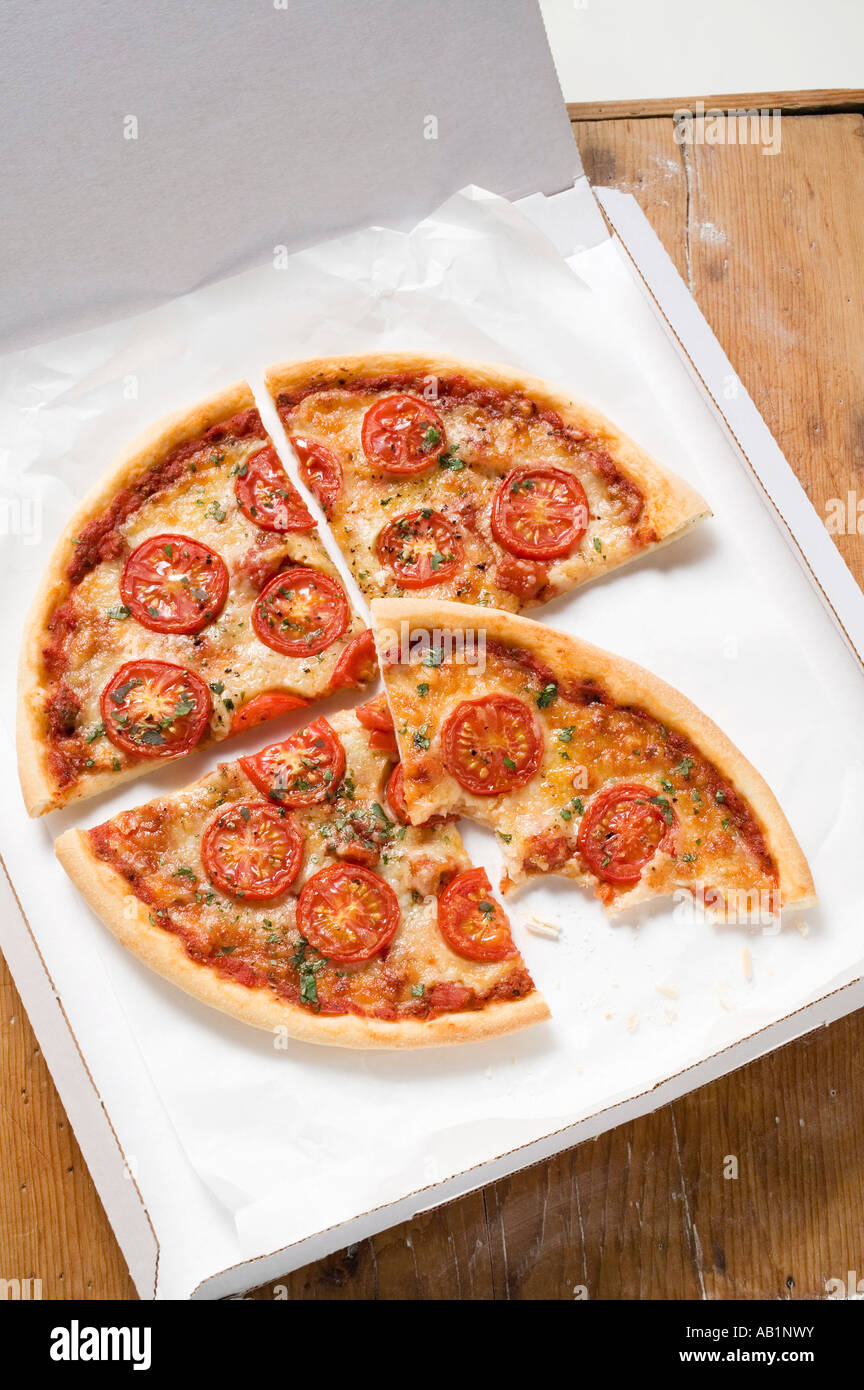 Cheese tomato pizza with oregano quartered in pizza box FoodCollection ...