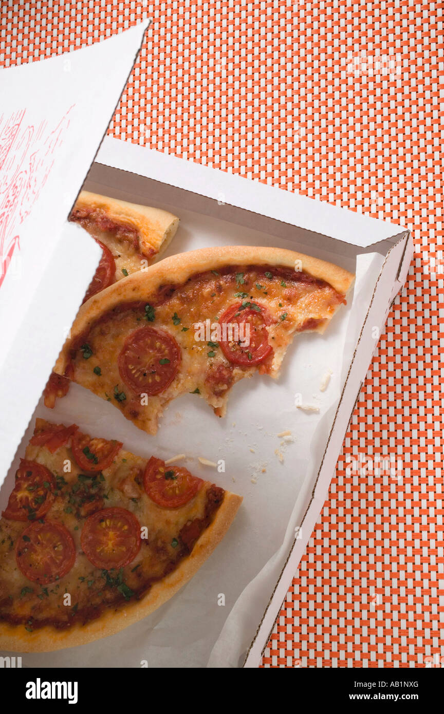 Cheese tomato pizza with oregano quartered in pizza box FoodCollection ...