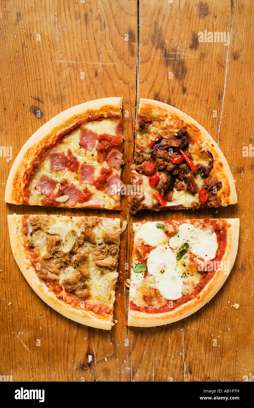 Pieces of four different pizzas on wooden background FoodCollection ...