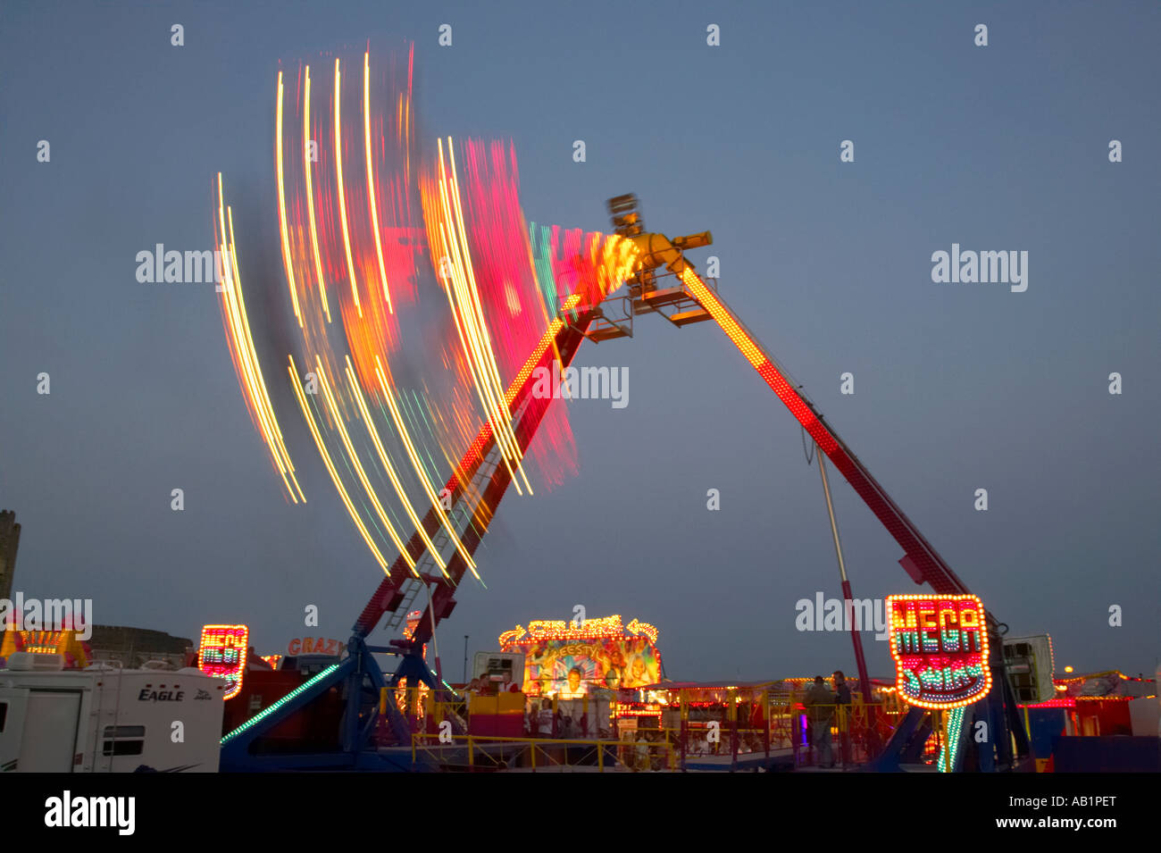 fairground ride in motion over fun park fair ground Stock Photo - Alamy