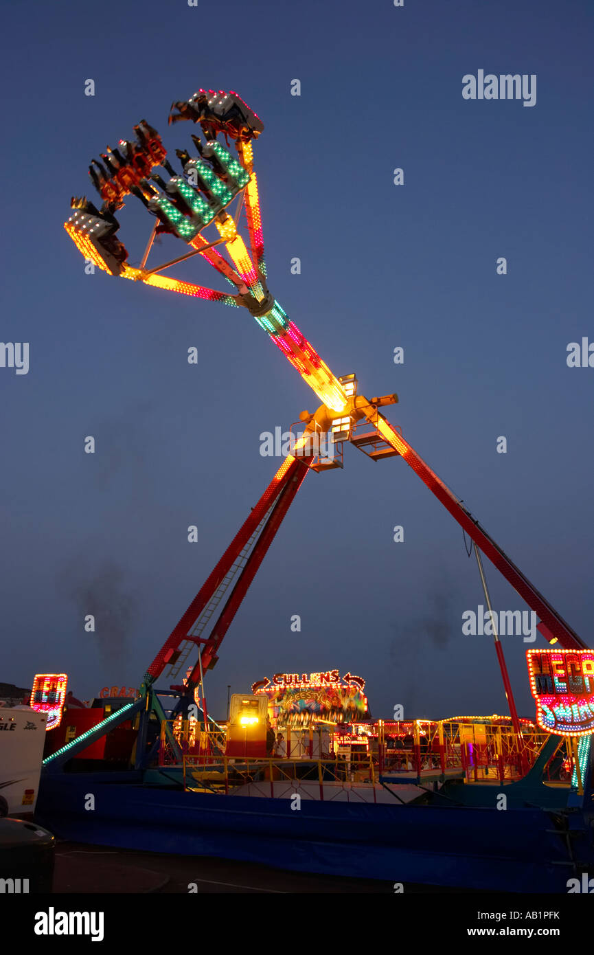 fairground ride carrying passengers upside down high over fun fair ...