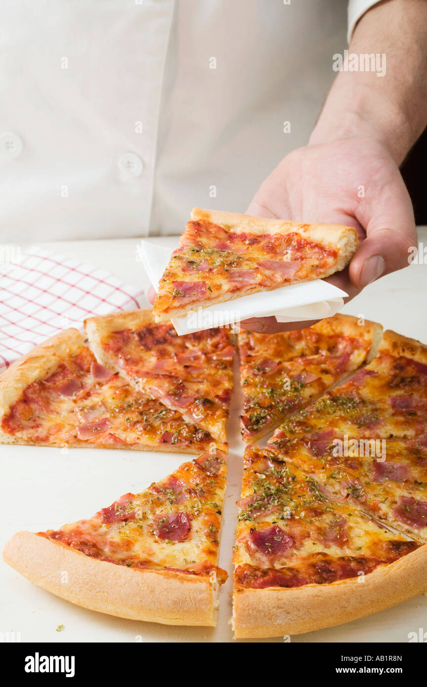 Chef holding slice of American style ham pizza FoodCollection Stock ...