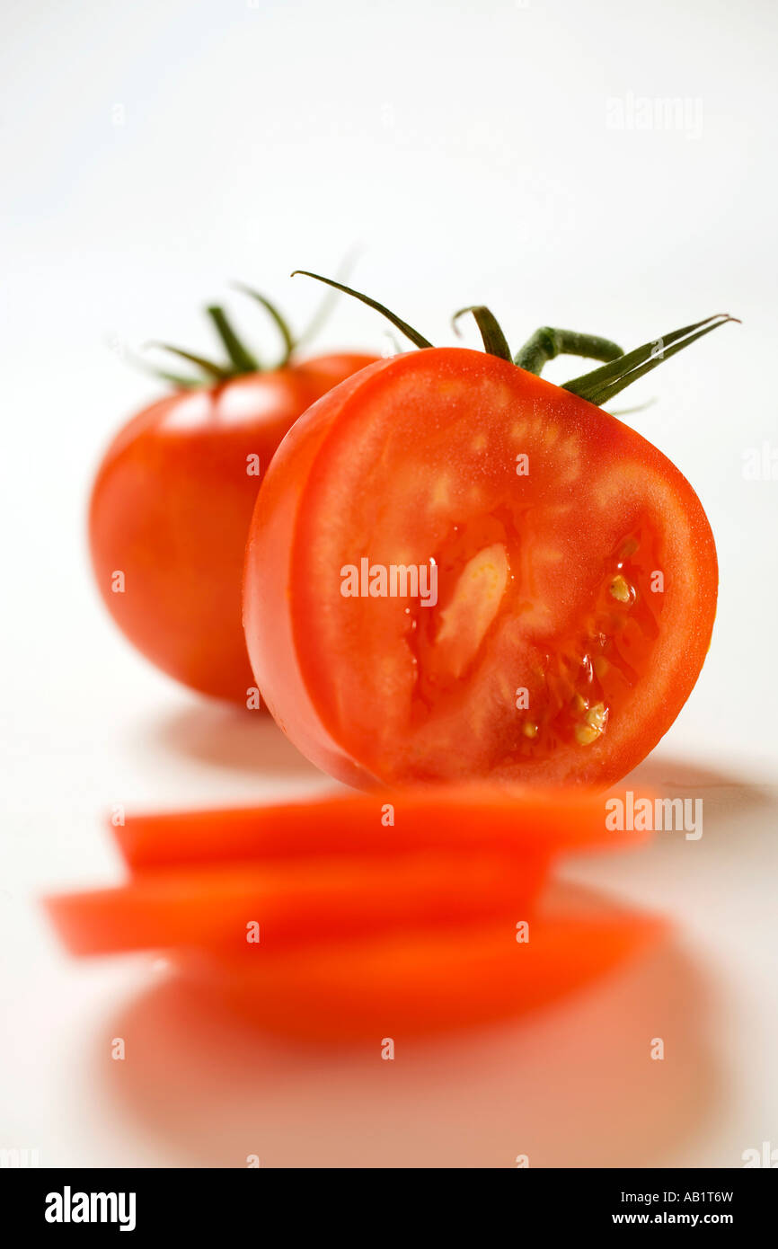 Two tomatoes one partly sliced FoodCollection Stock Photo - Alamy