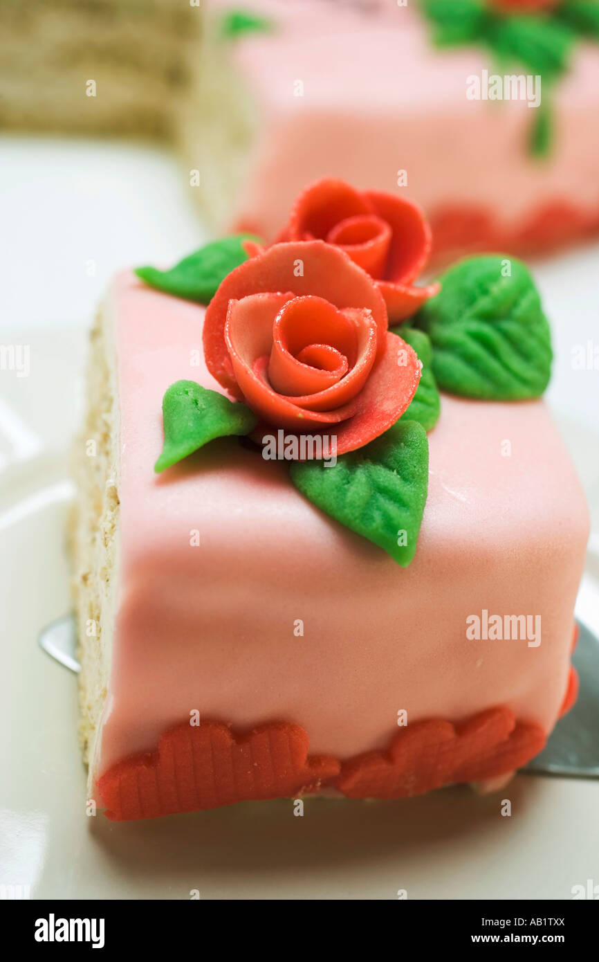 Piece of birthday cake with marzipan roses on cake server ...