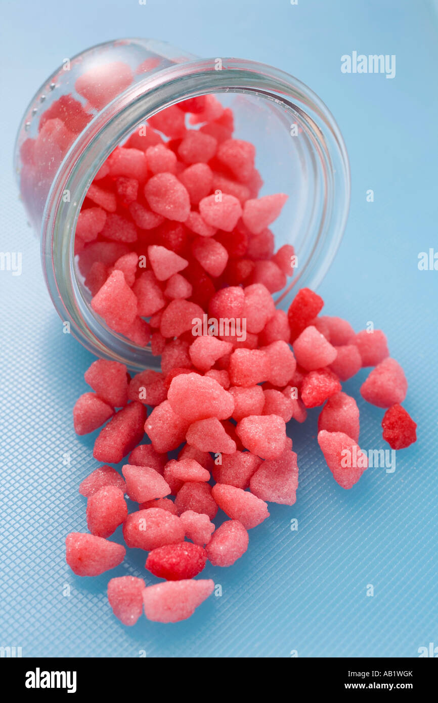 Small pink sweets falling out of a jar FoodCollection Stock Photo - Alamy