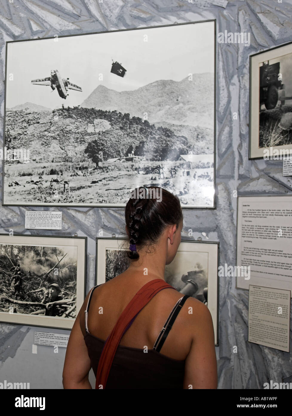 Young woman visitor examines Vietnam War gallery of photographs and ...