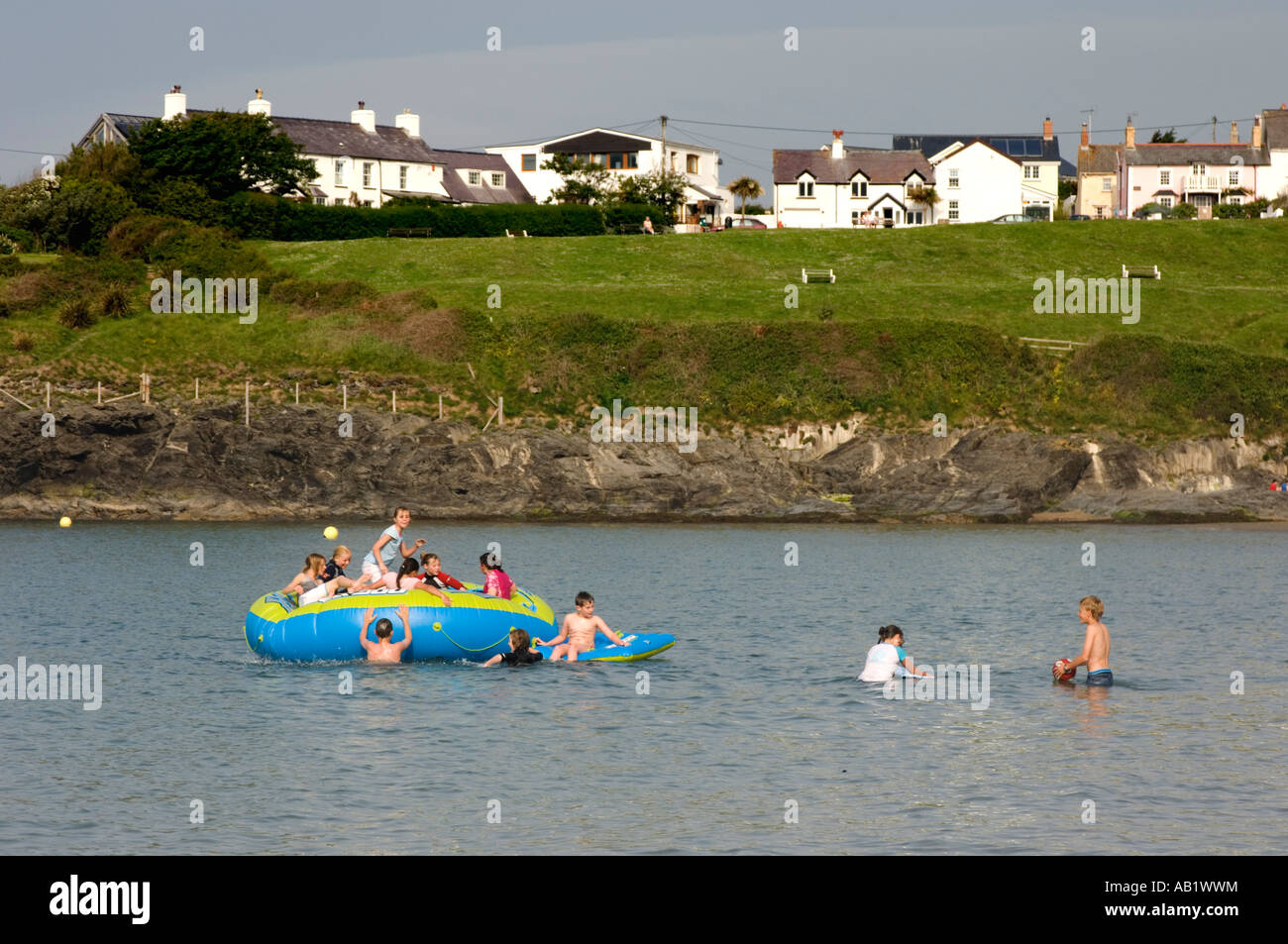 Group of children playing in the sea on inflatable raft Aberporth ...