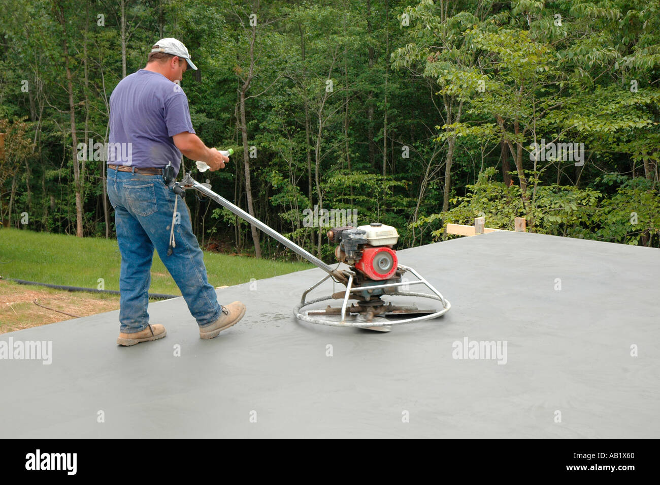 Workers smoothing cement basement floors on new home construction ...