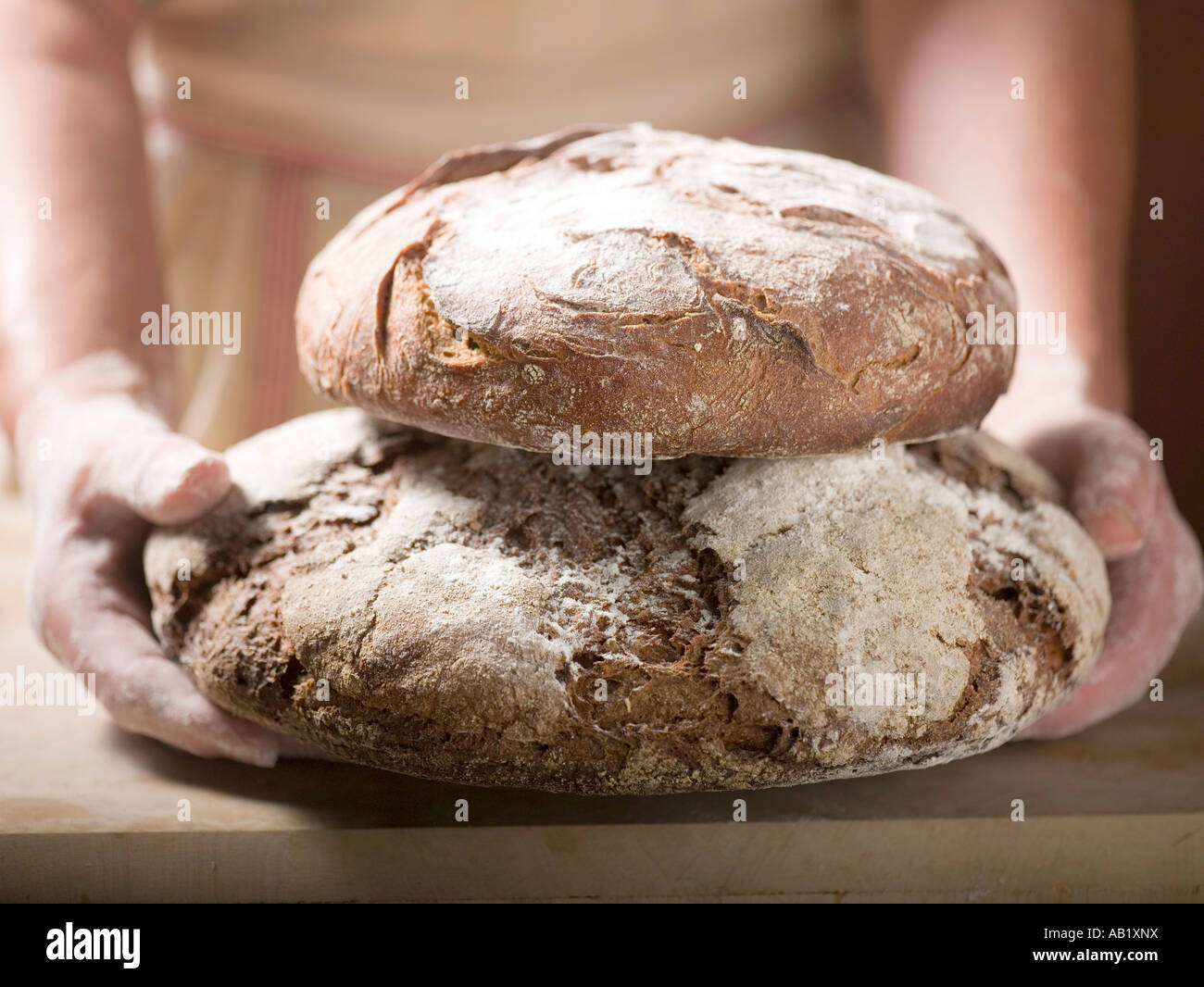 Hands holding two loaves of coarse rye bread FoodCollection Stock Photo ...