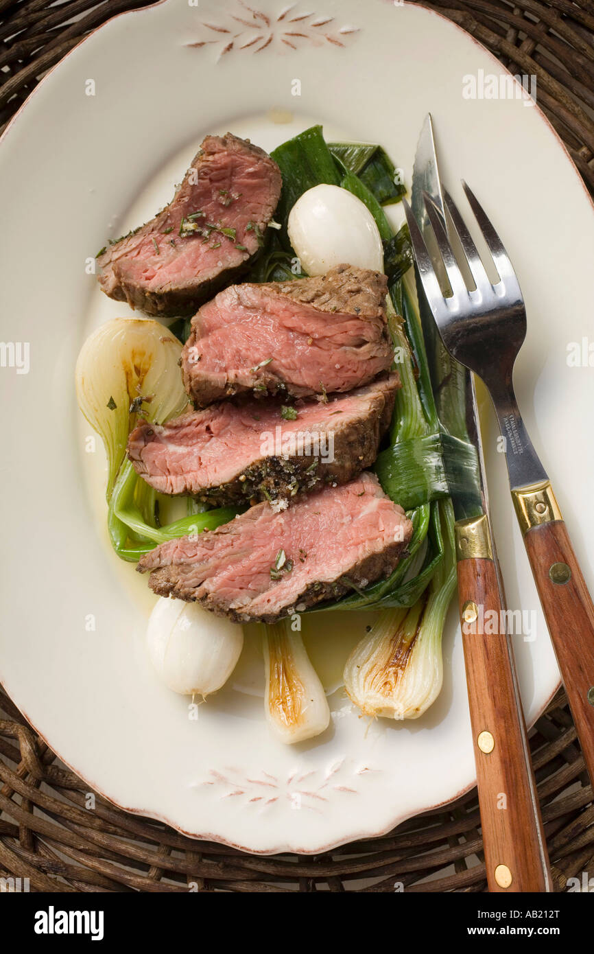 Beef steak sliced with roasted spring onions FoodCollection Stock Photo ...