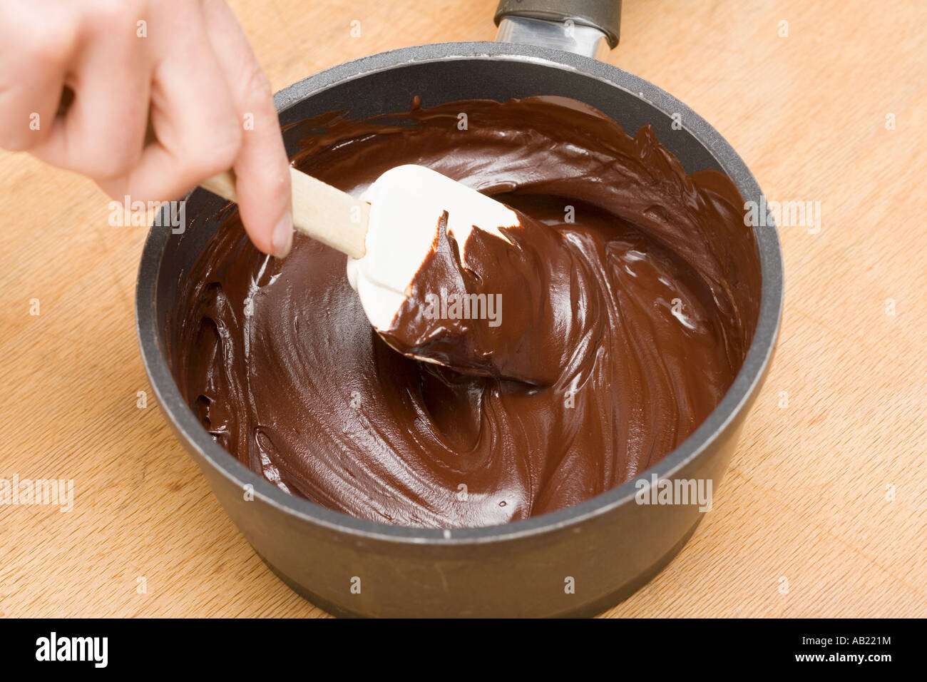 Stirring melted chocolate in pan with spatula FoodCollection Stock ...