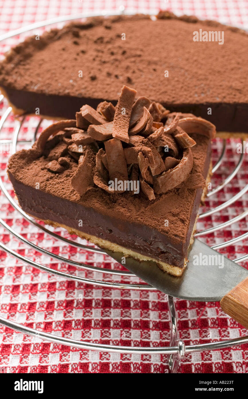 Chocolate tart on cake rack and piece on server FoodCollection Stock ...