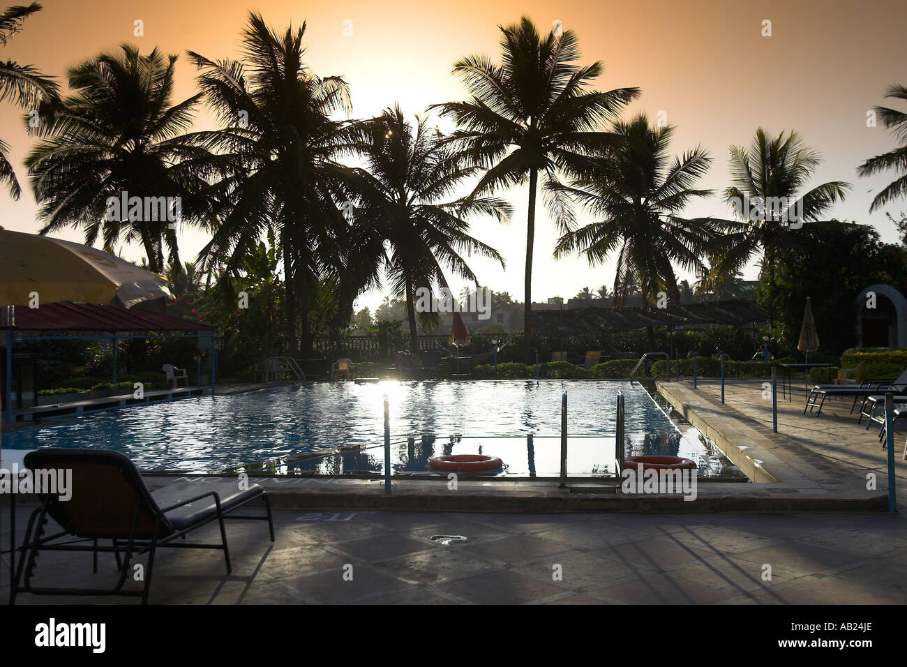 Sunset through palm trees at swimming pool Williams Beach Retreat Colva ...