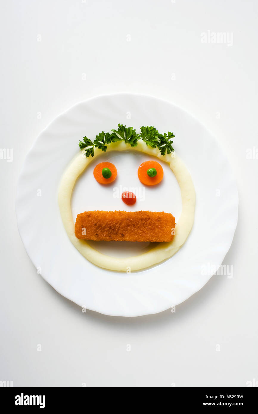 Face formed from fish finger mashed potato and vegetables ...