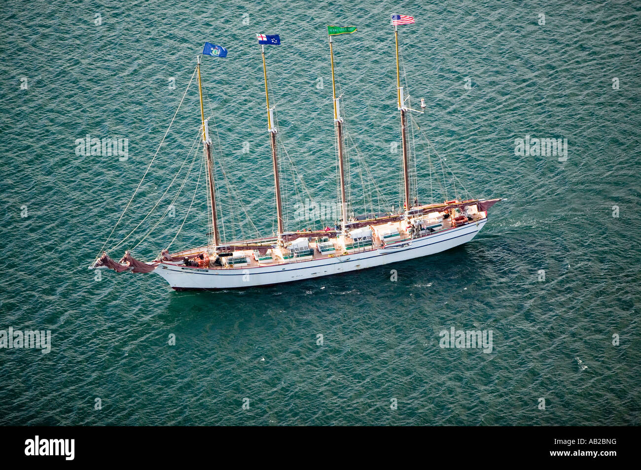 A tall ship with sails down cruises in bay outside of Acadia National ...