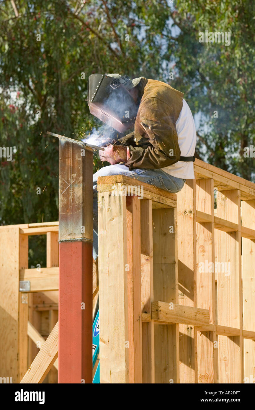 Glowing light of welder welding steel beam on California home Stock ...