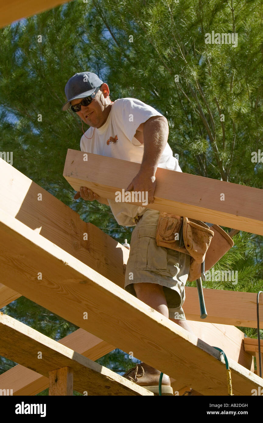 Carpenter lifts central beam of framing process in Southern California ...
