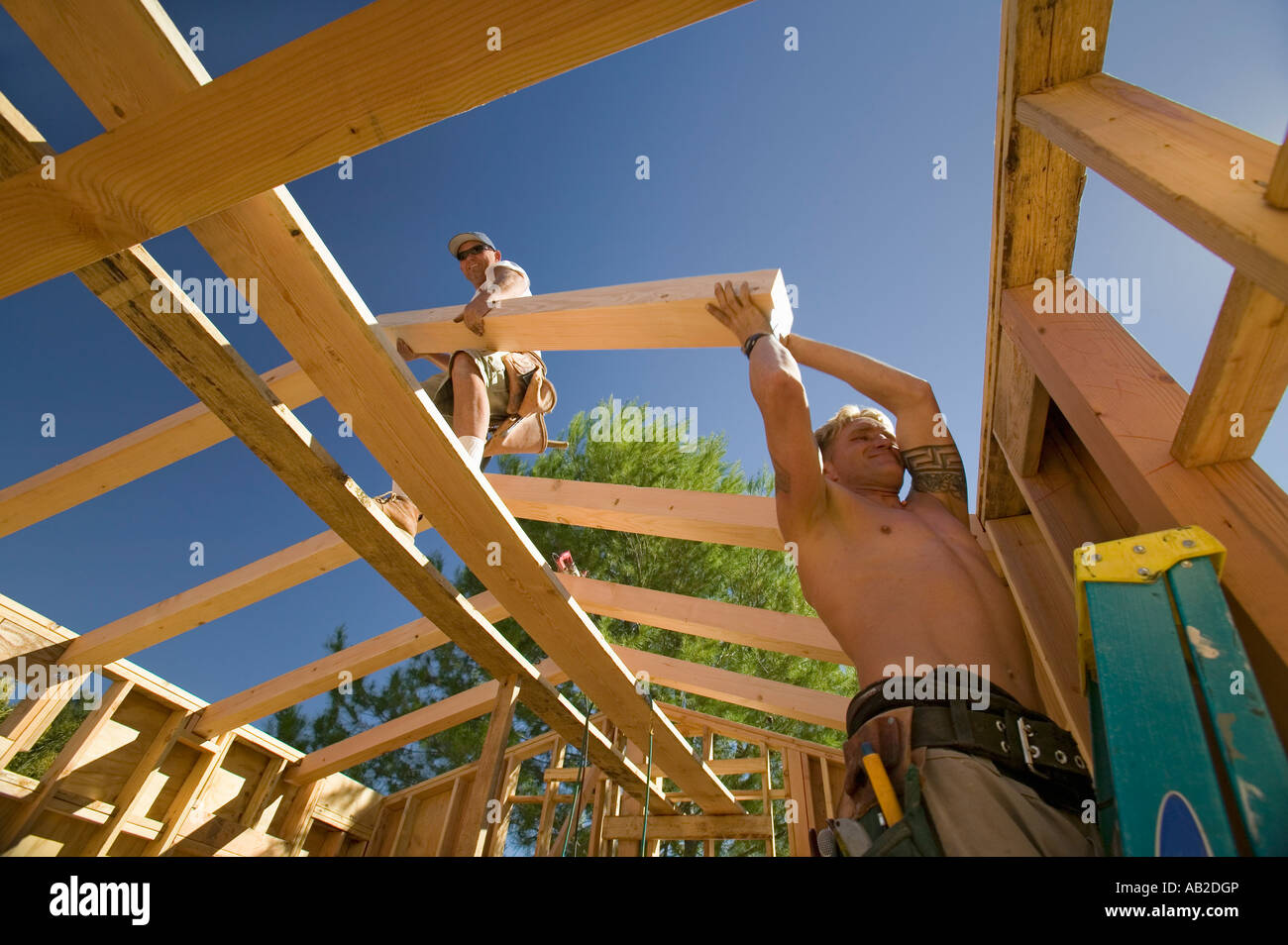 Workers position support beams into framing of house in Southern ...