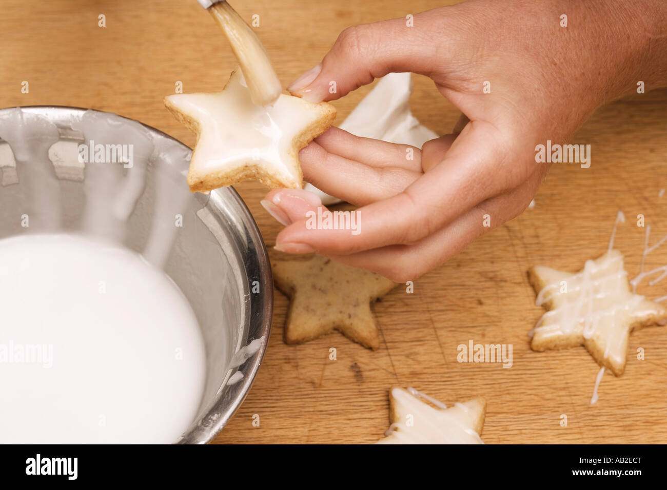 Brushing star shaped biscuits with glacé icing FoodCollection Stock ...