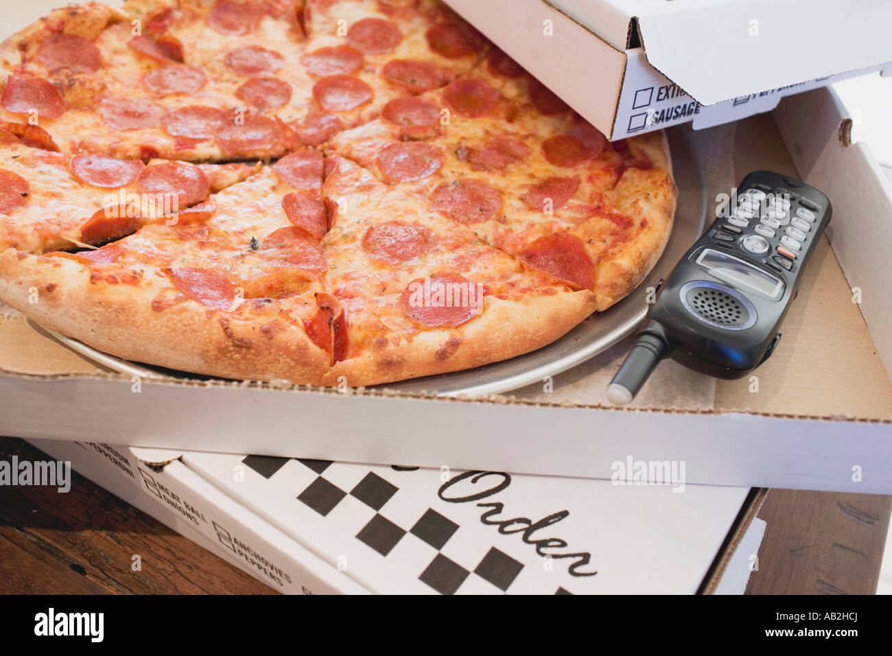 Pepperoni pizza in pizza box telephone beside it FoodCollection Stock ...