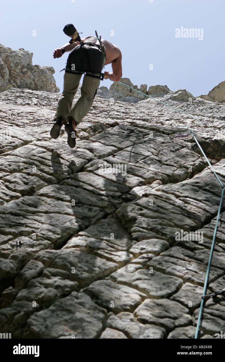 person abseiling a steep rocky wall Stock Photo - Alamy
