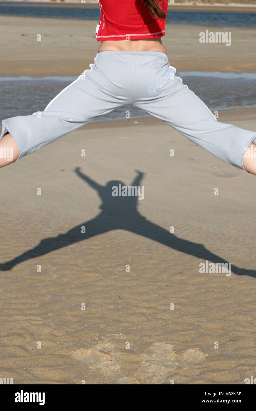 woman leaping, shadow on sand Stock Photo - Alamy