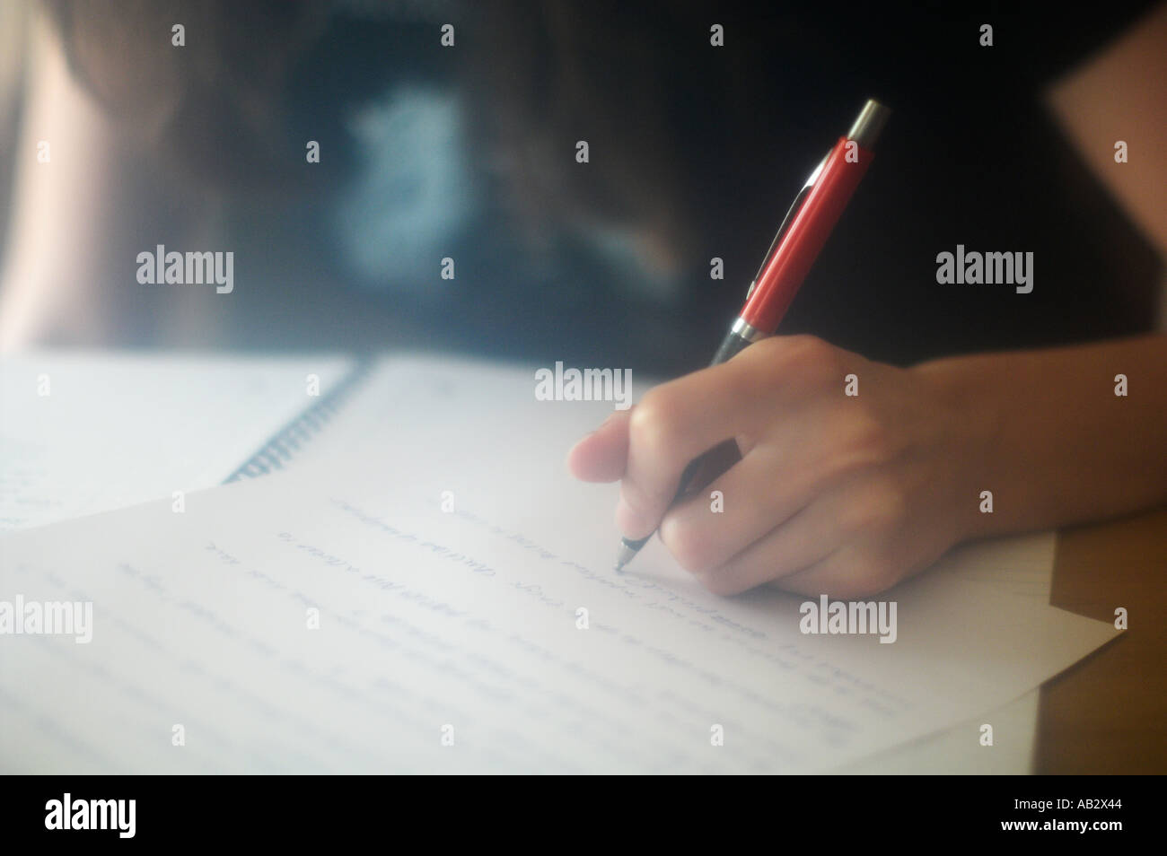 Writing A young left handed woman writing Stock Photo - Alamy
