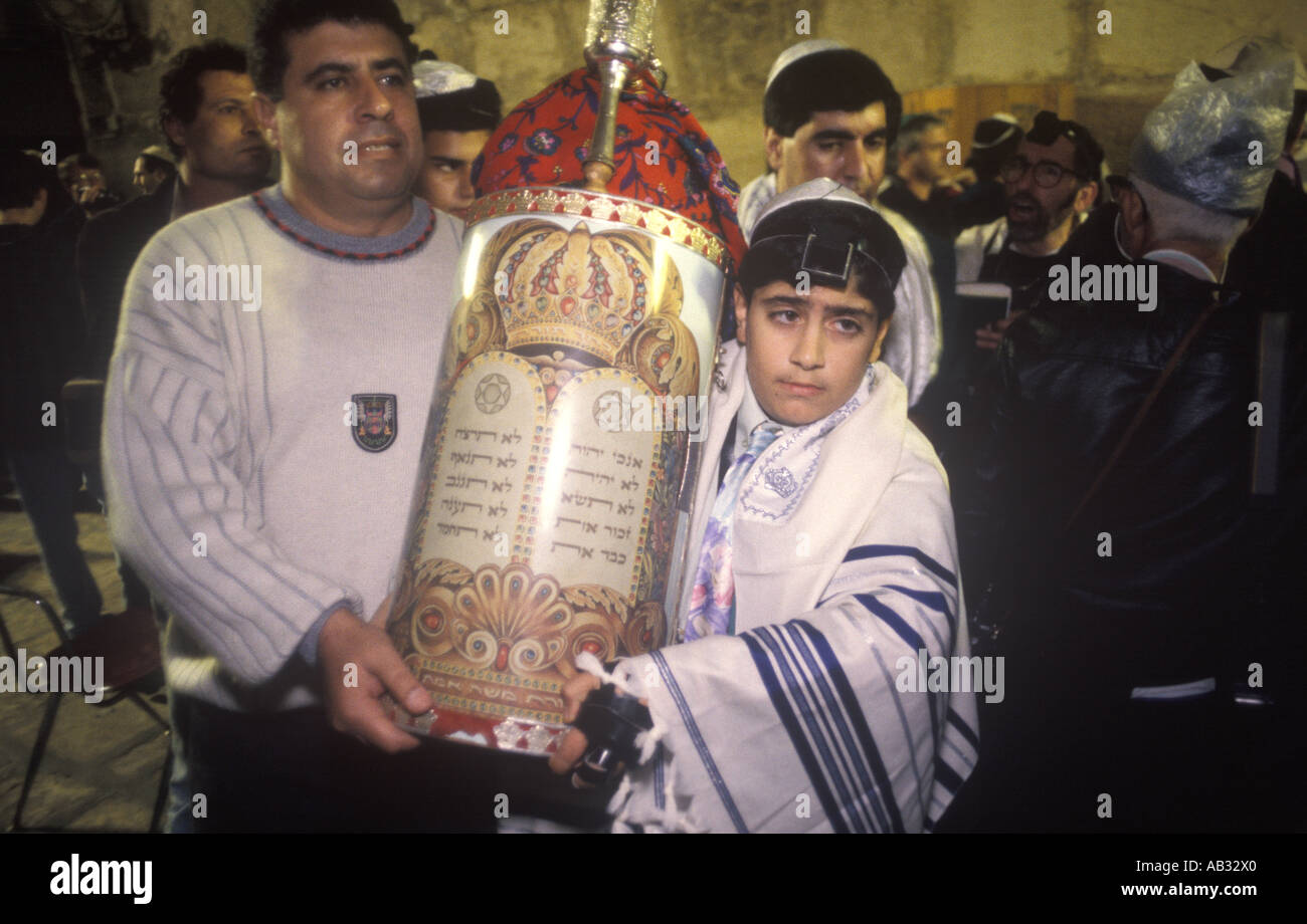A father helps his son carry the Torah Scrolls at the end of the latter ...