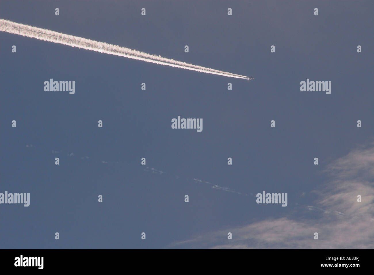 Airplane trailing condensation trails Stock Photo - Alamy