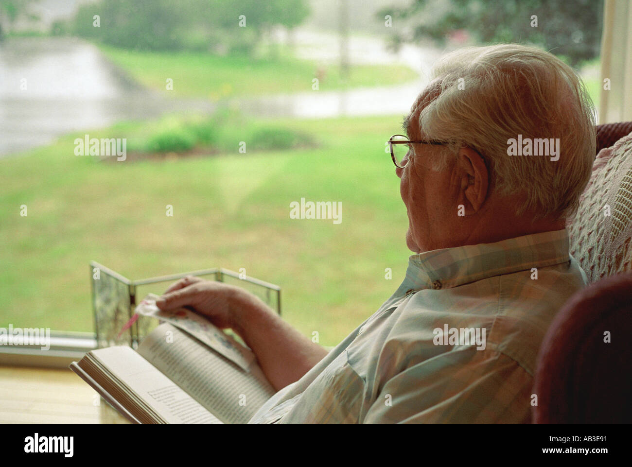 old man reading and looking out the window of his home in Saint John ...