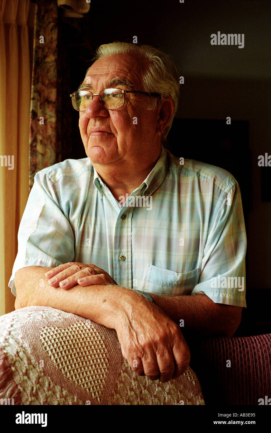 old man leaning on chair while looking out the window in his New ...