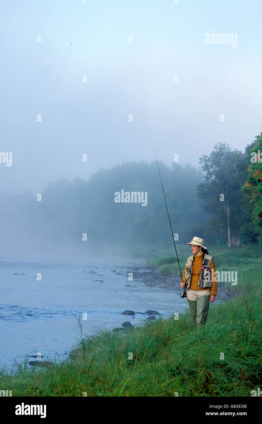 woman fly fishing for salmon along the Miramichi River New Brunswick ...