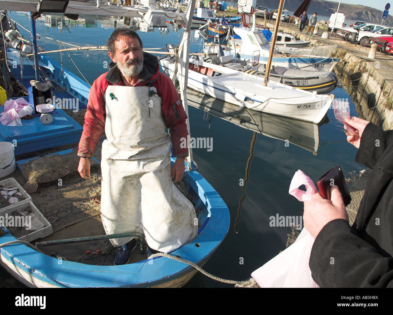 Fisherman selling his early catch Stock Photo - Alamy
