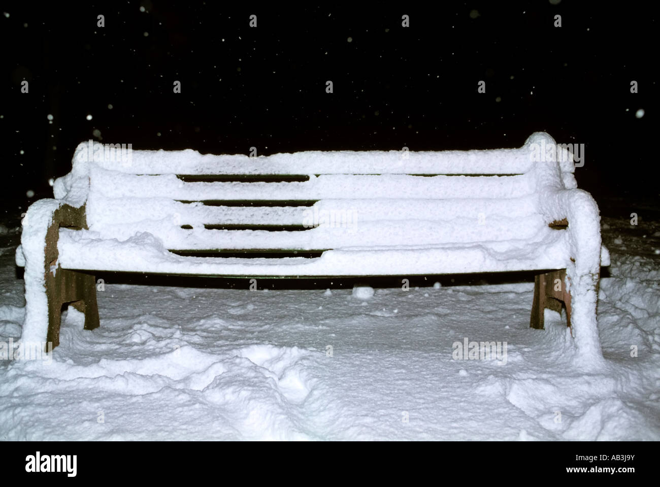 Park bench cover with snow at night Stock Photo - Alamy