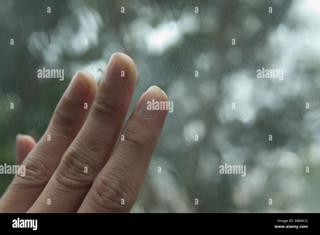 hand touching window pane on a gloomy day Stock Photo - Alamy
