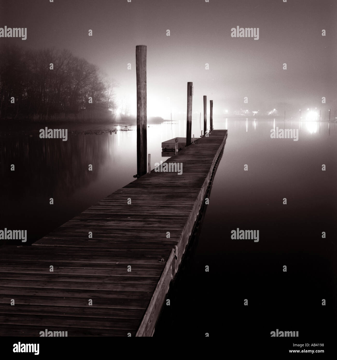 Dock extending out into foggy night black and white landscape Stock ...