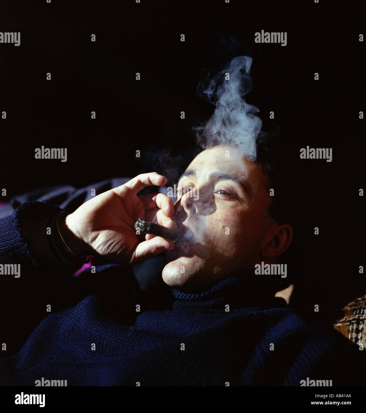 Young man 20 30 smoking a cigar relaxing Stock Photo - Alamy