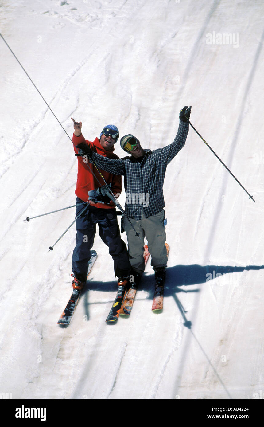 Two male skiers on a T bar ski tow waving to their friends Stock Photo ...