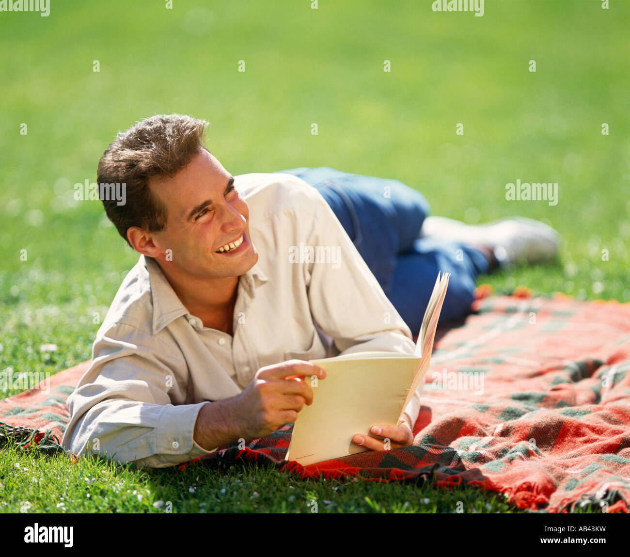 Man outdoors reading book Stock Photo - Alamy