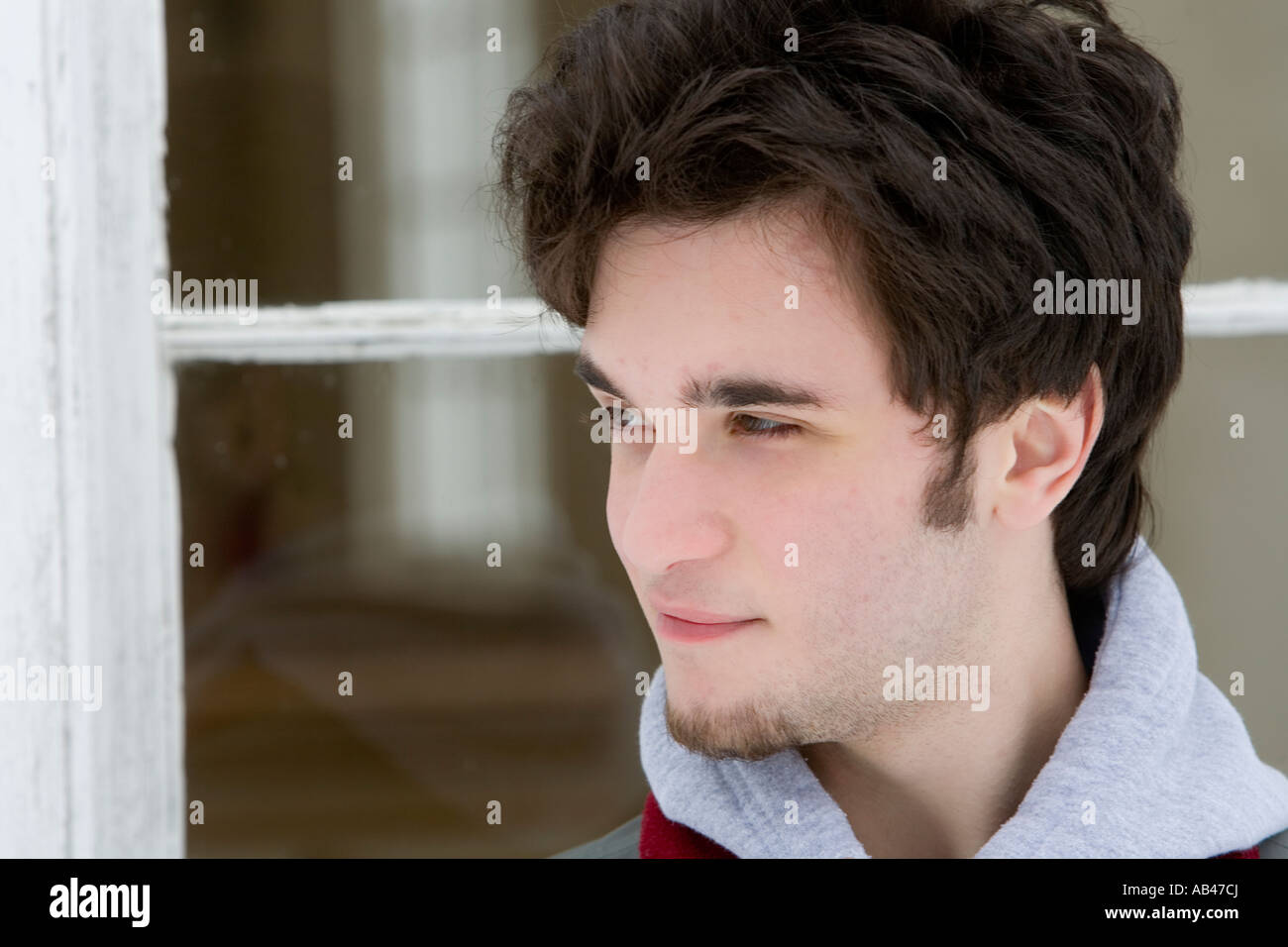 A young man poses against a window Stock Photo - Alamy