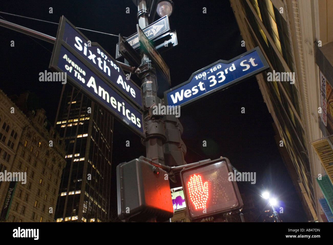 A street corner sign and traffic signal in New York City at nighttime ...