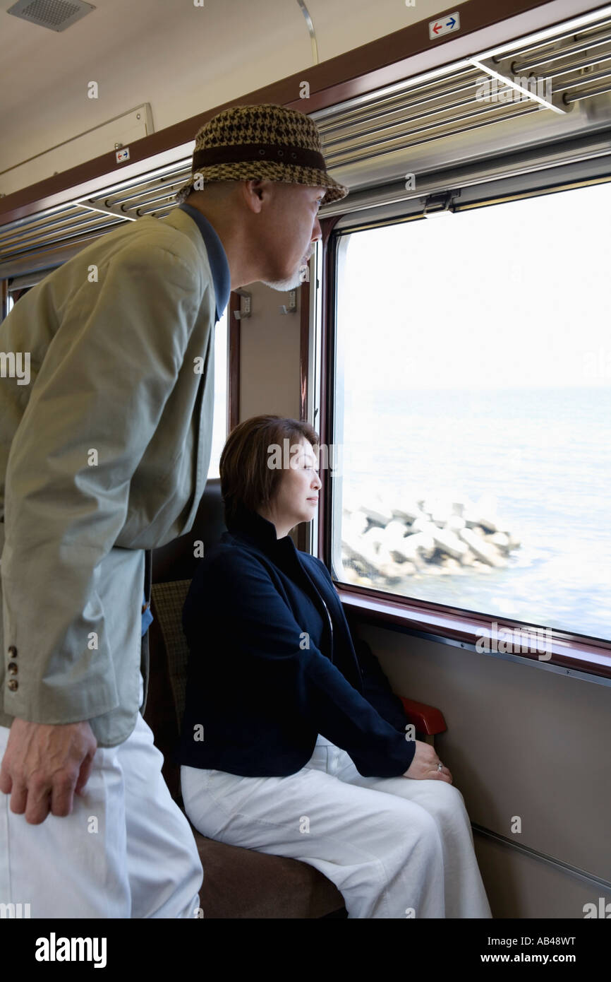 Senior couple looking out train window Stock Photo - Alamy