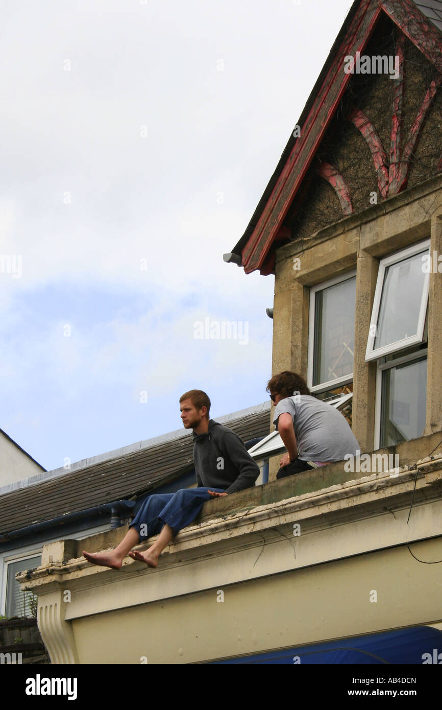 young men sitting on a roof Stock Photo - Alamy