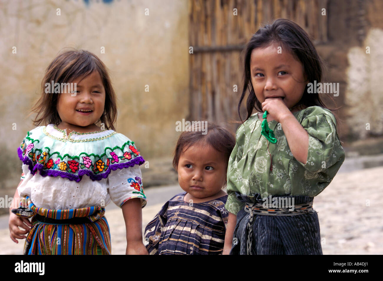 Three local smiling hispanic children siblings pose for the camera ...