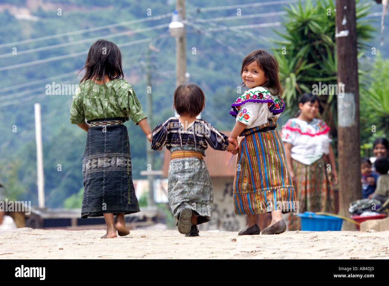 Three local poor hispanic children siblings walk down the street, one ...