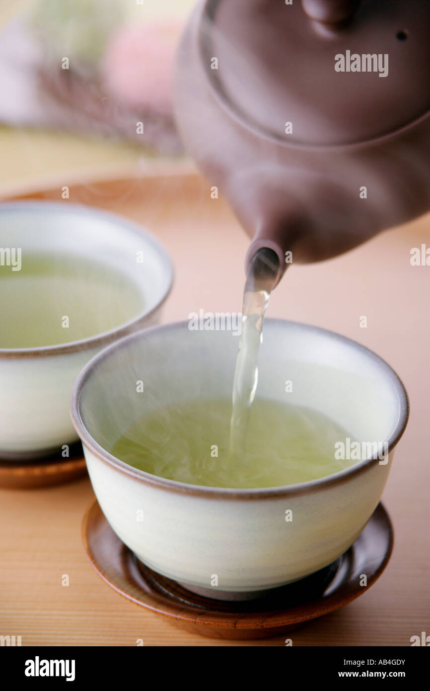 Green tea pouring into cup Stock Photo - Alamy